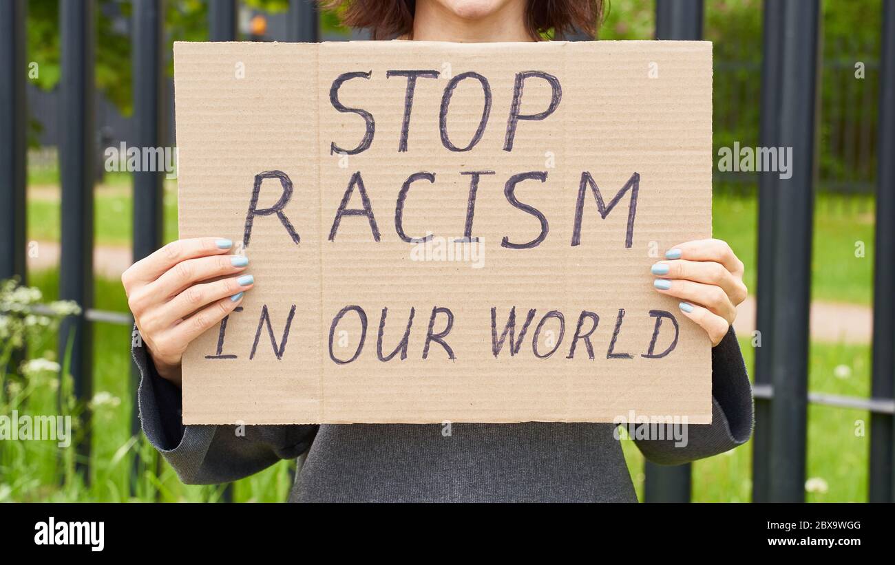 Stop racism concept. Unrecognizable white person holds sign with text ...