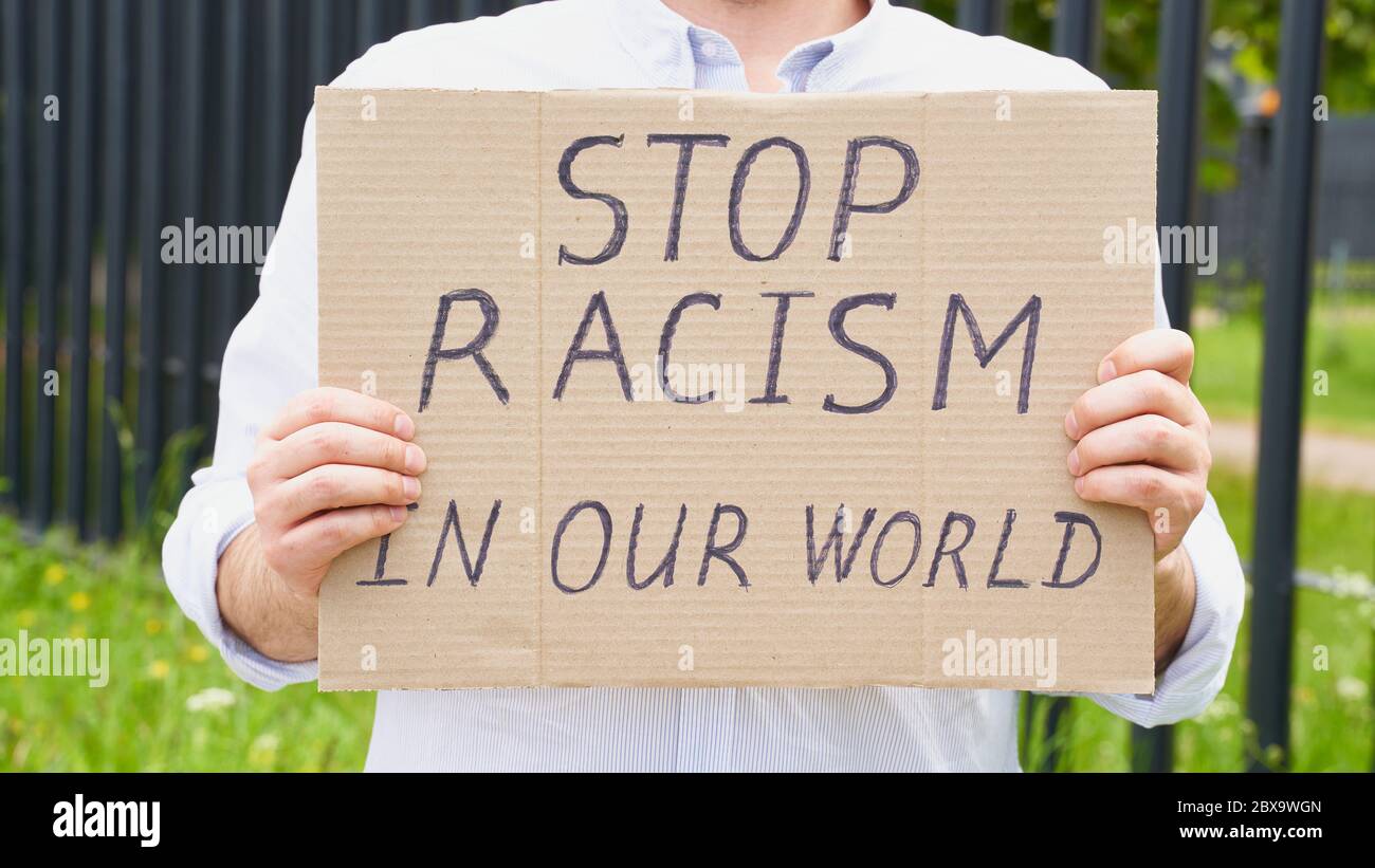 Stop racism concept. Unrecognizable white person holds sign with text ...