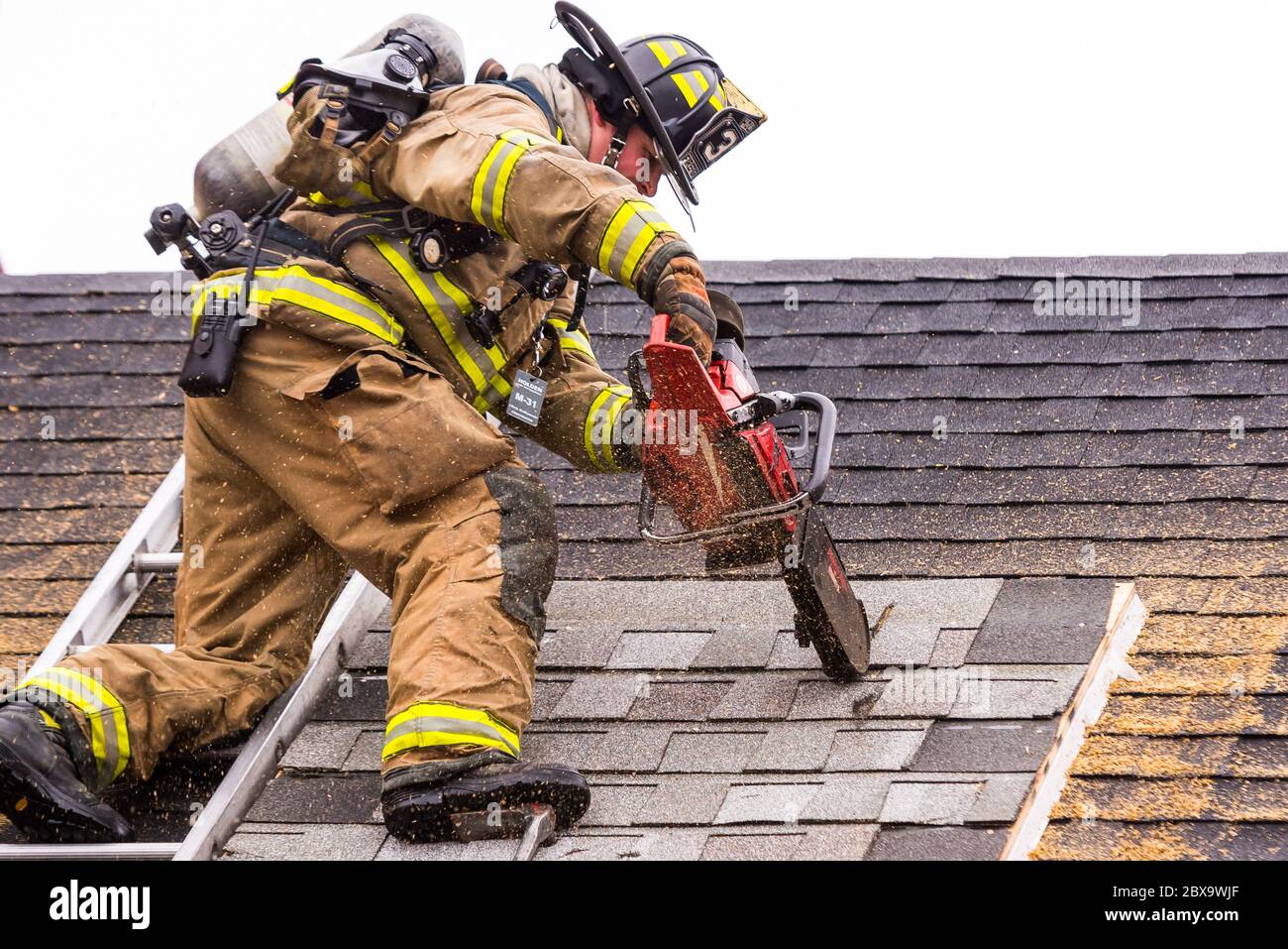 Firefighter cutting into a roof during firefighter training at the ...