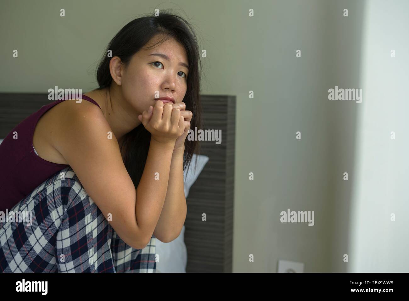 lifestyle indoors portrait of young attractive sad and depressed Asian ...
