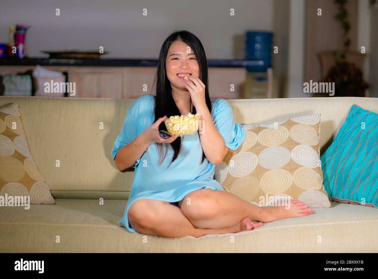 young happy and excited Asian Korean woman with TV remote controller ...