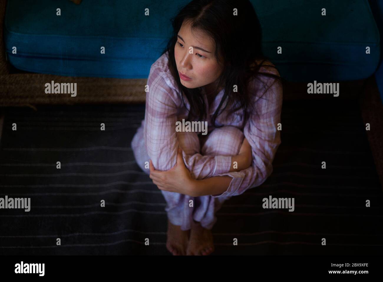dramatic dark portrait of young beautiful sad and depressed Asian ...