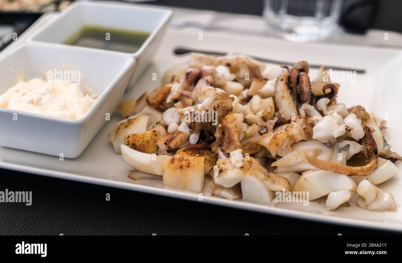 Grilled squid, grilled cuttlefish served as a Spanish tapa with garlic ...
