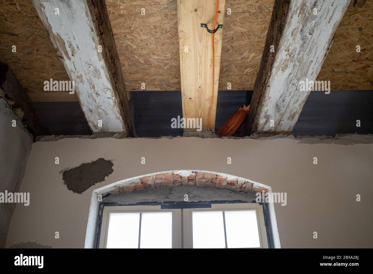 in an old building old wooden beams are supported with new wooden beams ...