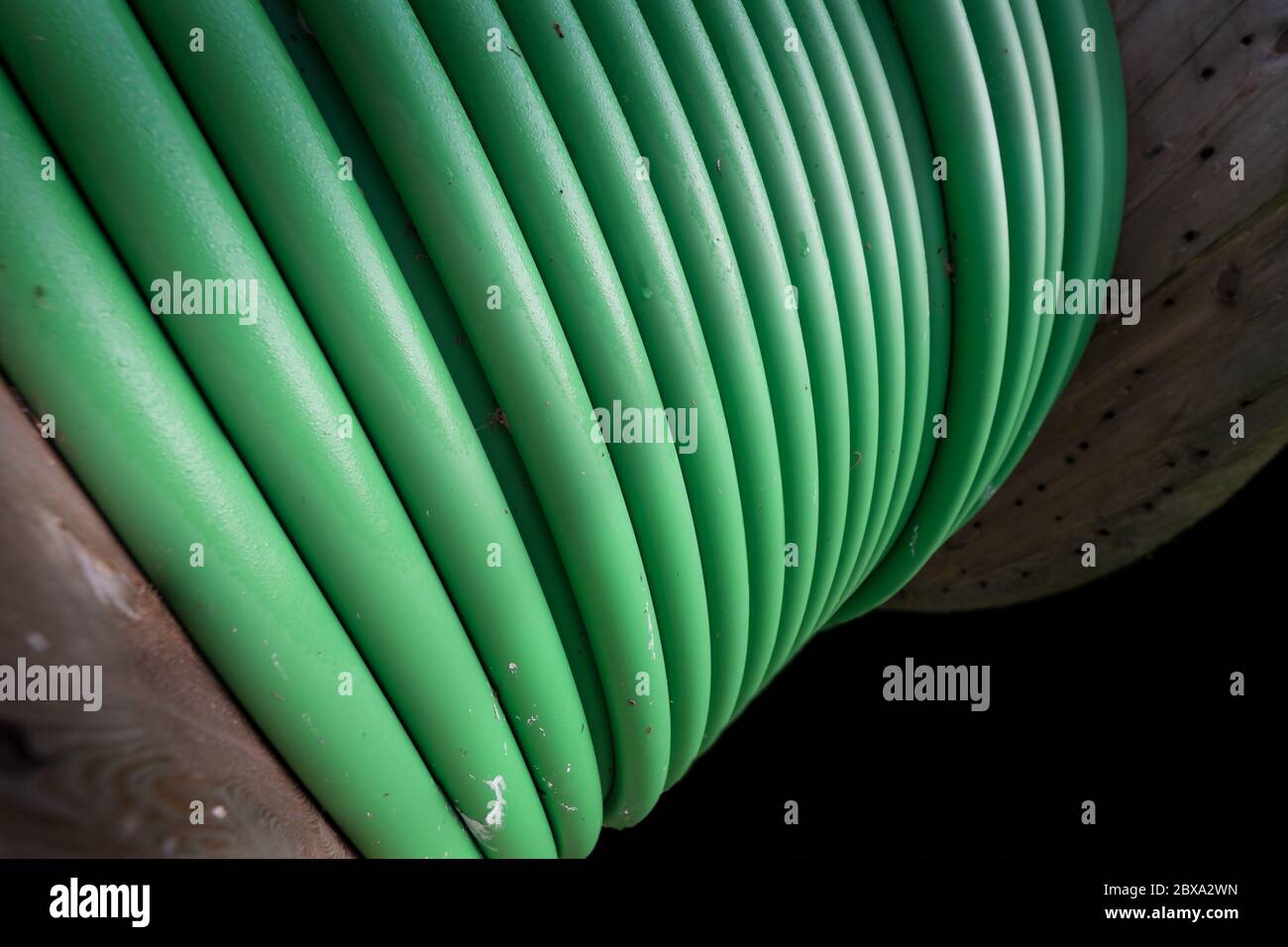 Wooden coil of green Electric Cable outdoor. Isolated on black Stock ...