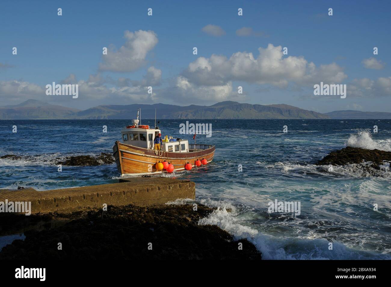 Passenger tour boat approaching the landing jetty on the Isle of Staffa ...