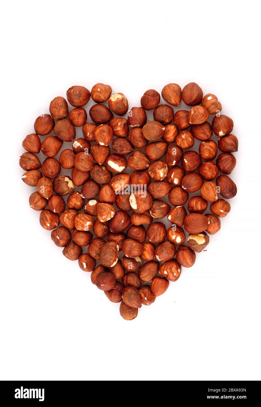 Organic unpeeled hazelnuts in heart symbol isolated on white background ...