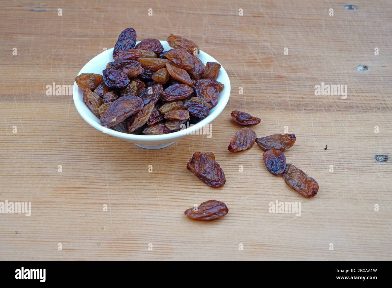 Plateful of Organic Raisins and Spilled Raisins on Wooden Background ...