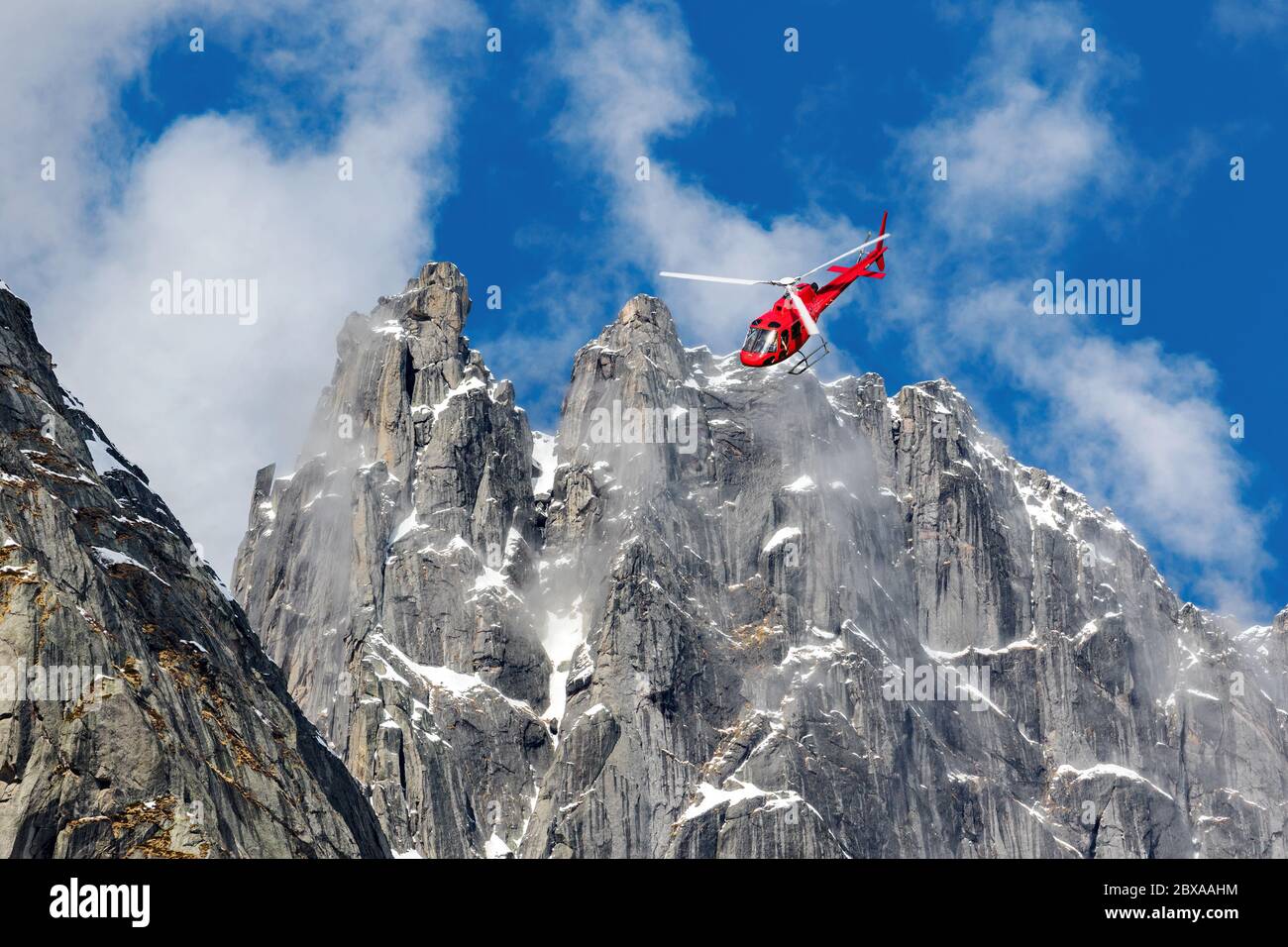 red helicopter flying over the alps Stock Photo - Alamy