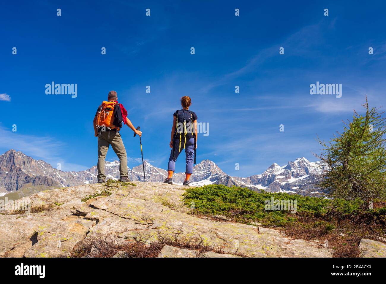 Couple with backpack on mountain top. Two people looking at scenic ...