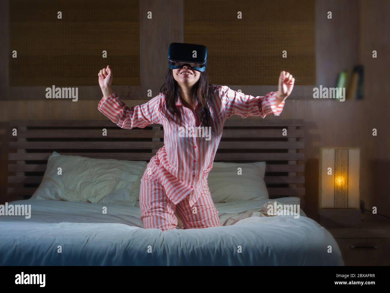 young happy and excited woman playing with virtual reality VR goggles ...