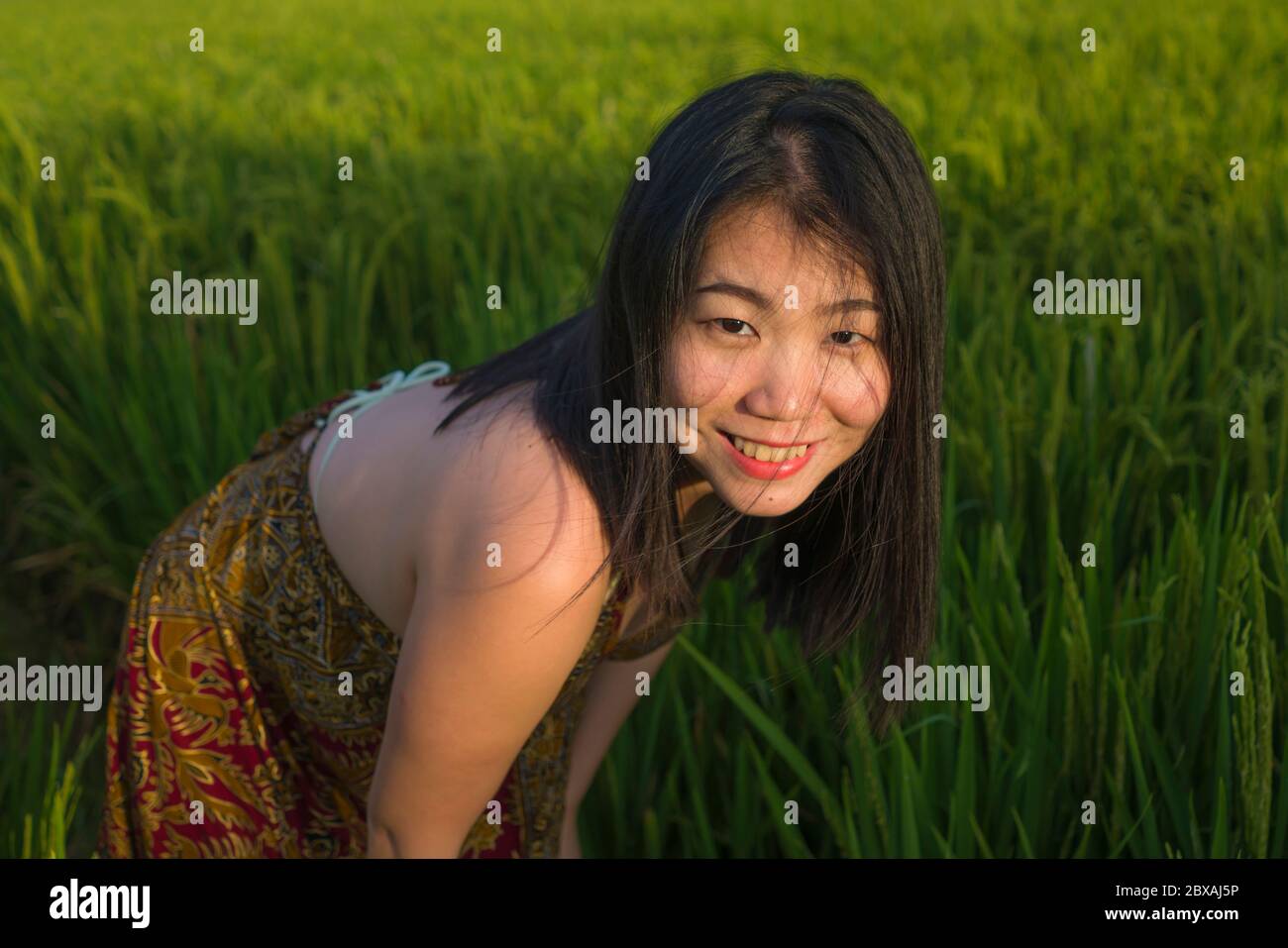 young happy and beautiful Asian woman enjoying nature at rice field ...