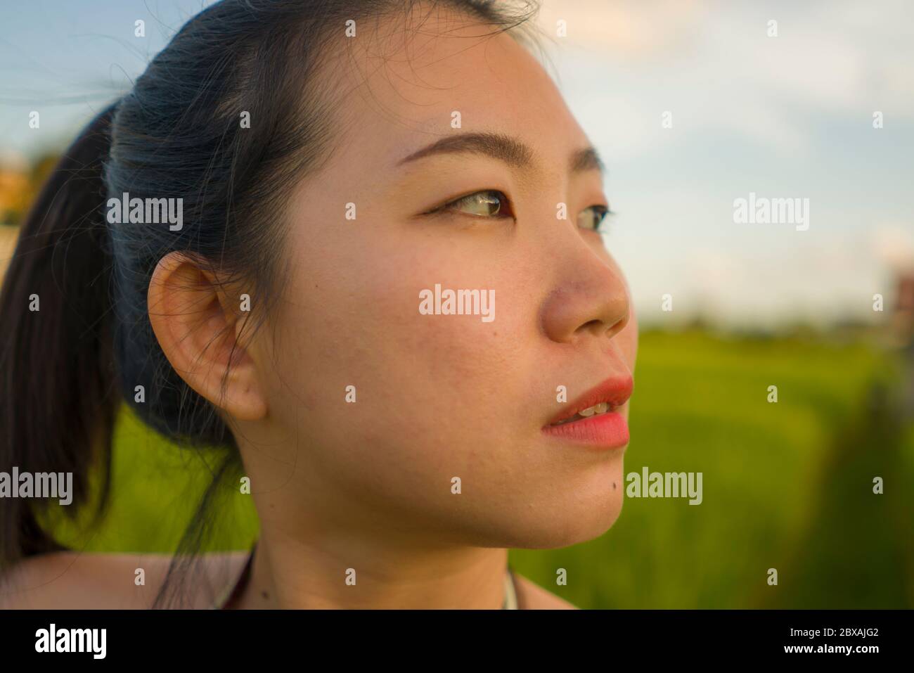 young happy and beautiful Asian woman enjoying nature at rice field ...