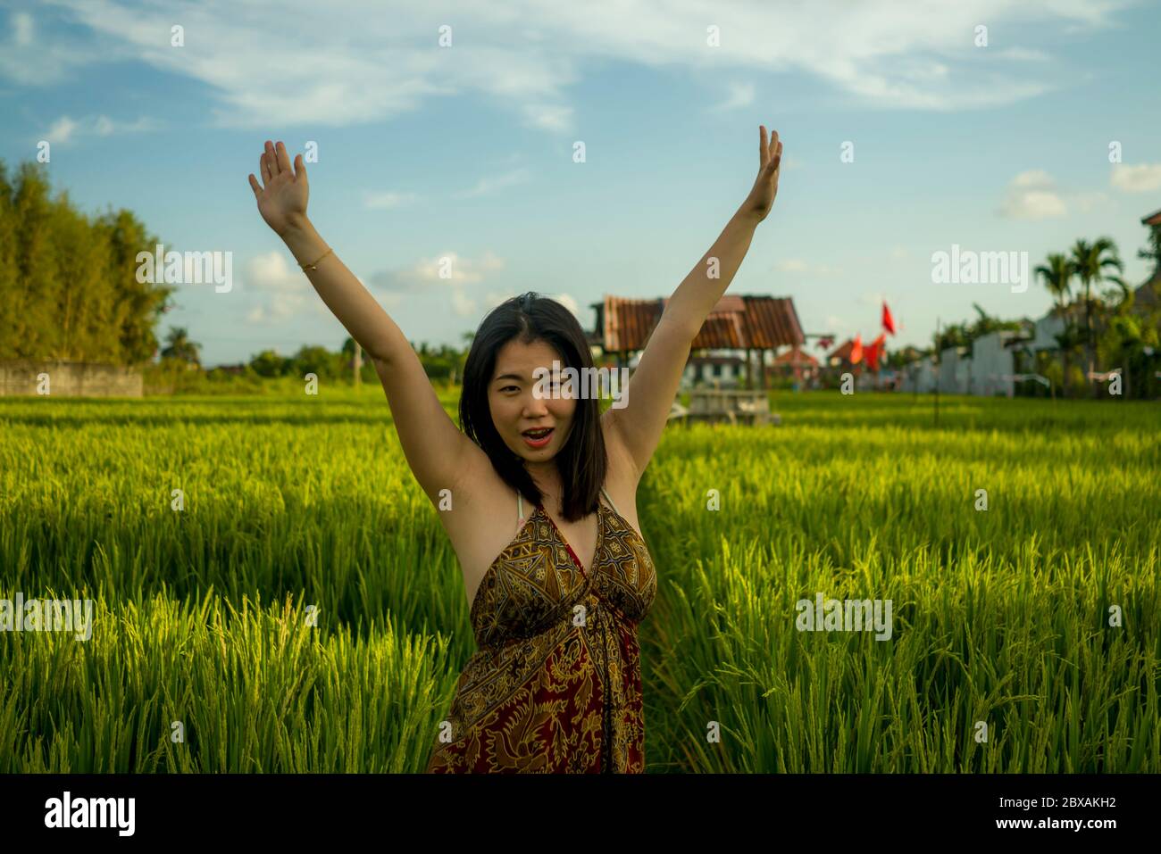 young happy and beautiful Asian woman enjoying nature at rice field ...