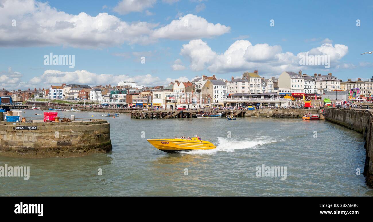 A speedboat giving rides to visitors leaving the harbour at Bridlington ...