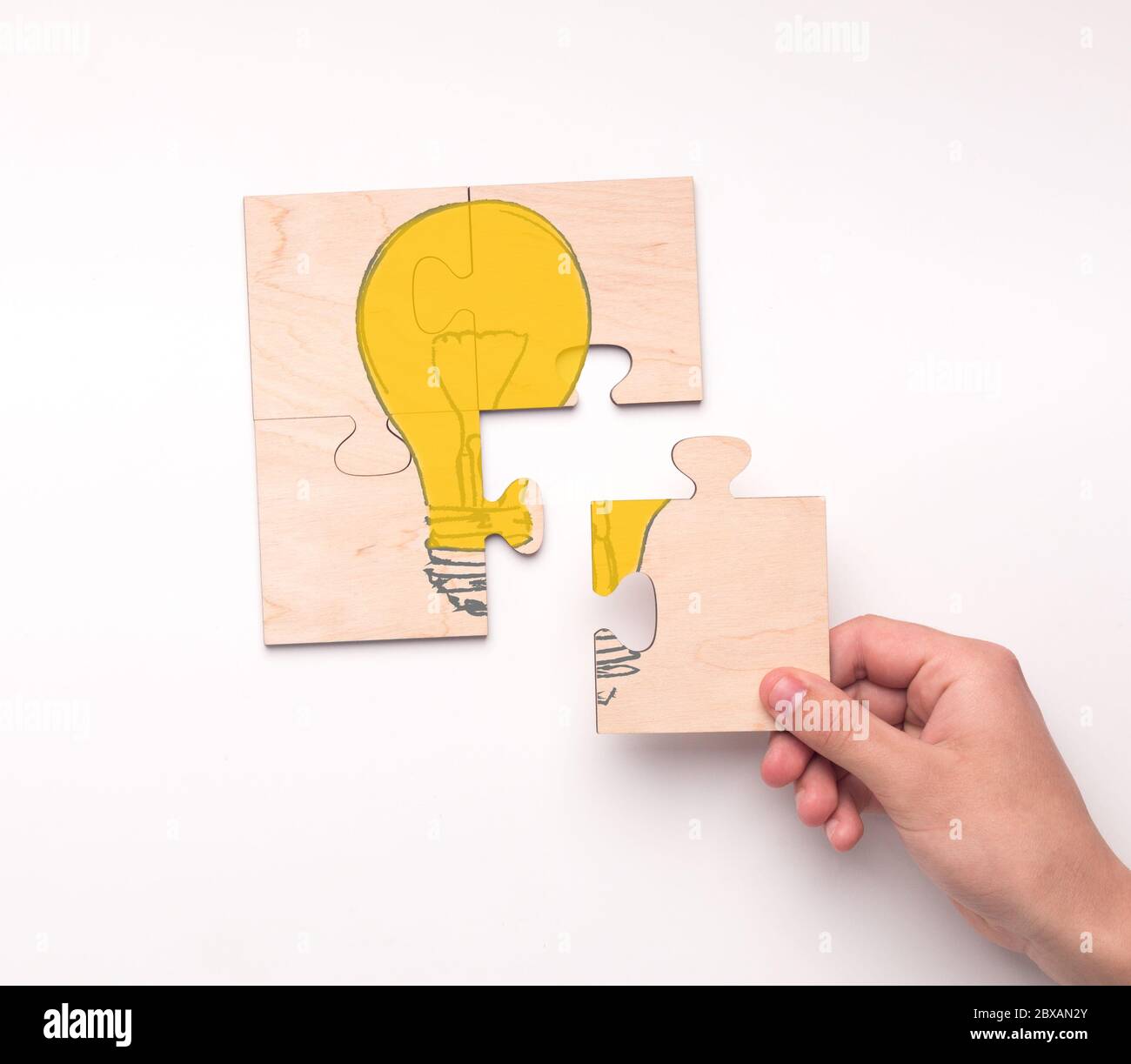 Hand solving puzzle with drawn light bulb on white background Stock ...