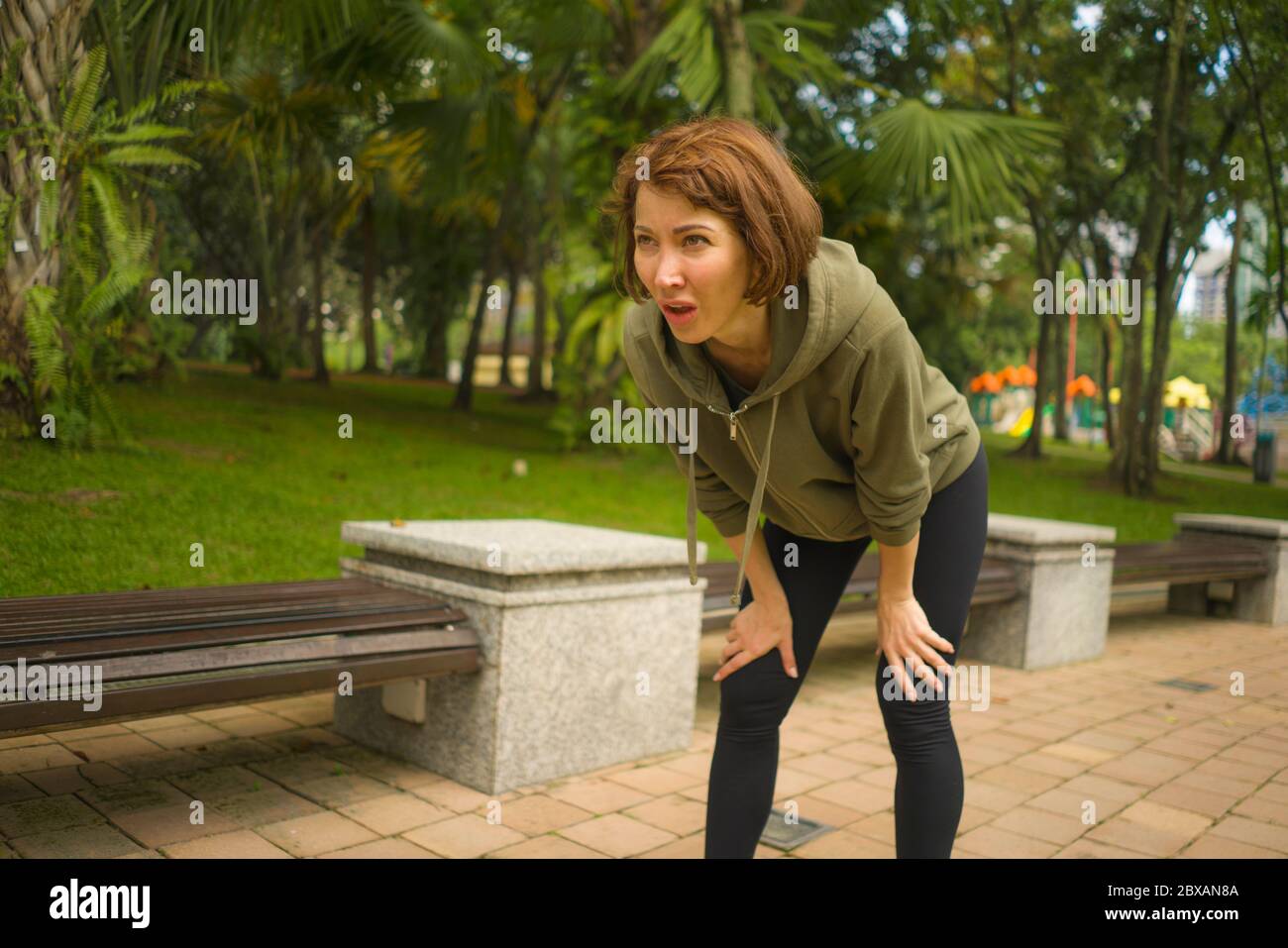 outdoors portrait of young attractive tired and breathless jogger woman ...