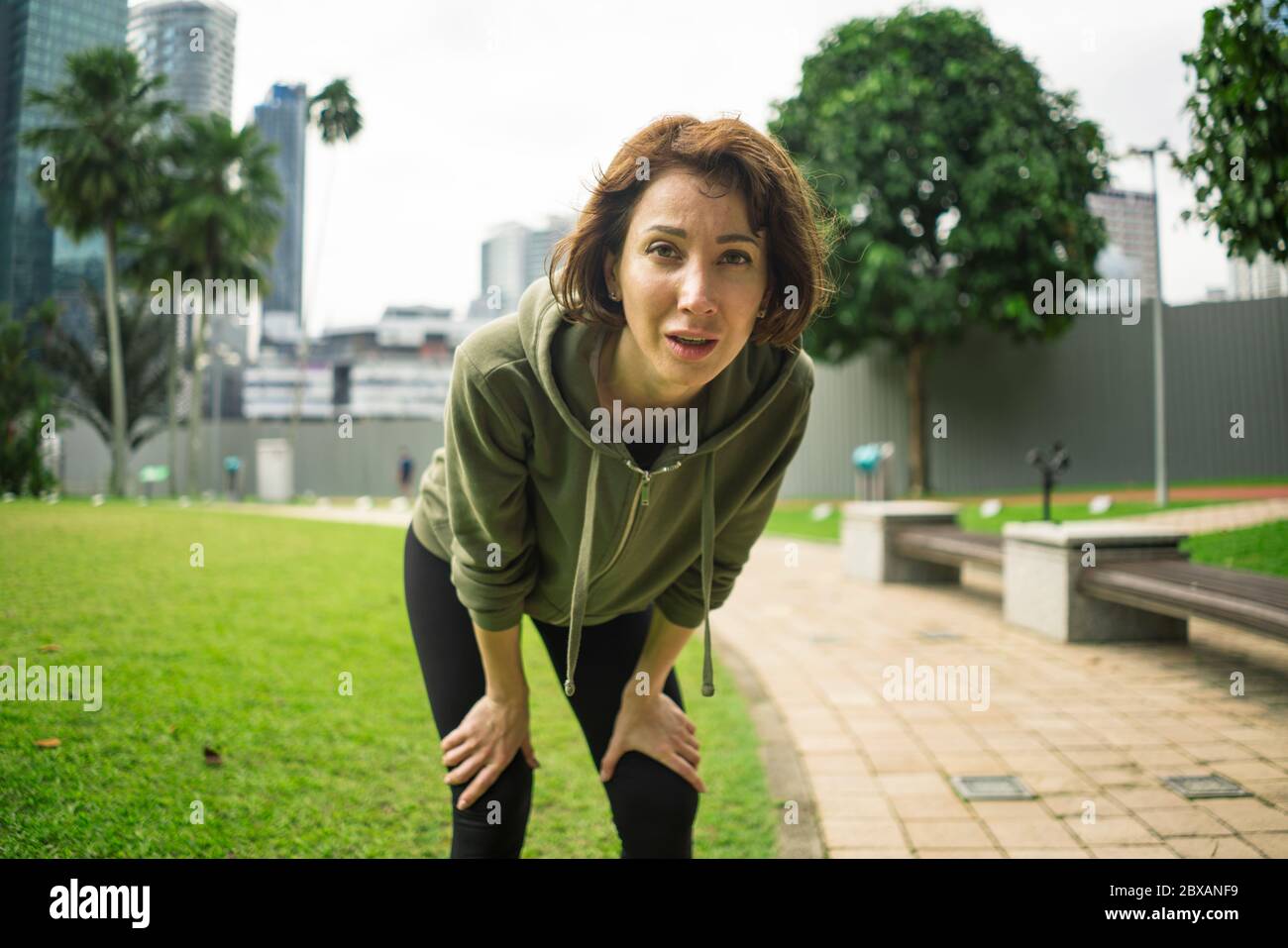 outdoors portrait of young attractive tired and breathless jogger woman ...