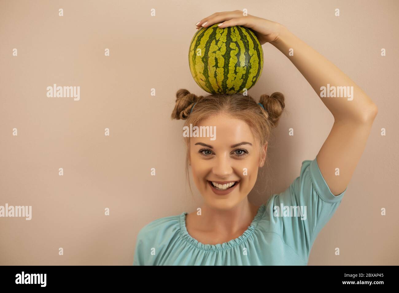 Cute playful woman holding watermelon on her head.Toned image Stock ...