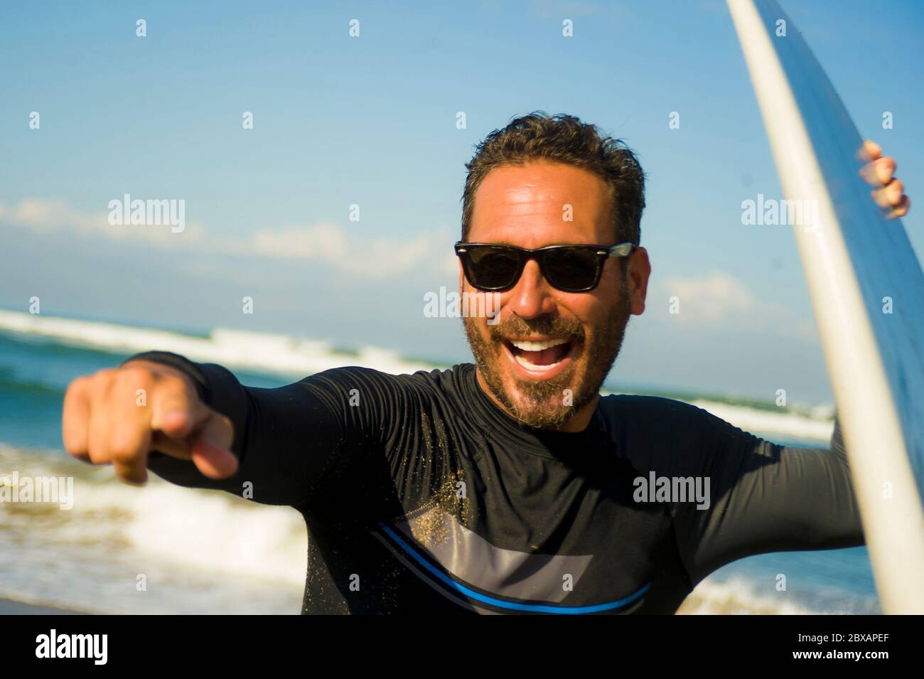 lifestyle portrait of attractive and happy surfer man 3os to 40s in ...