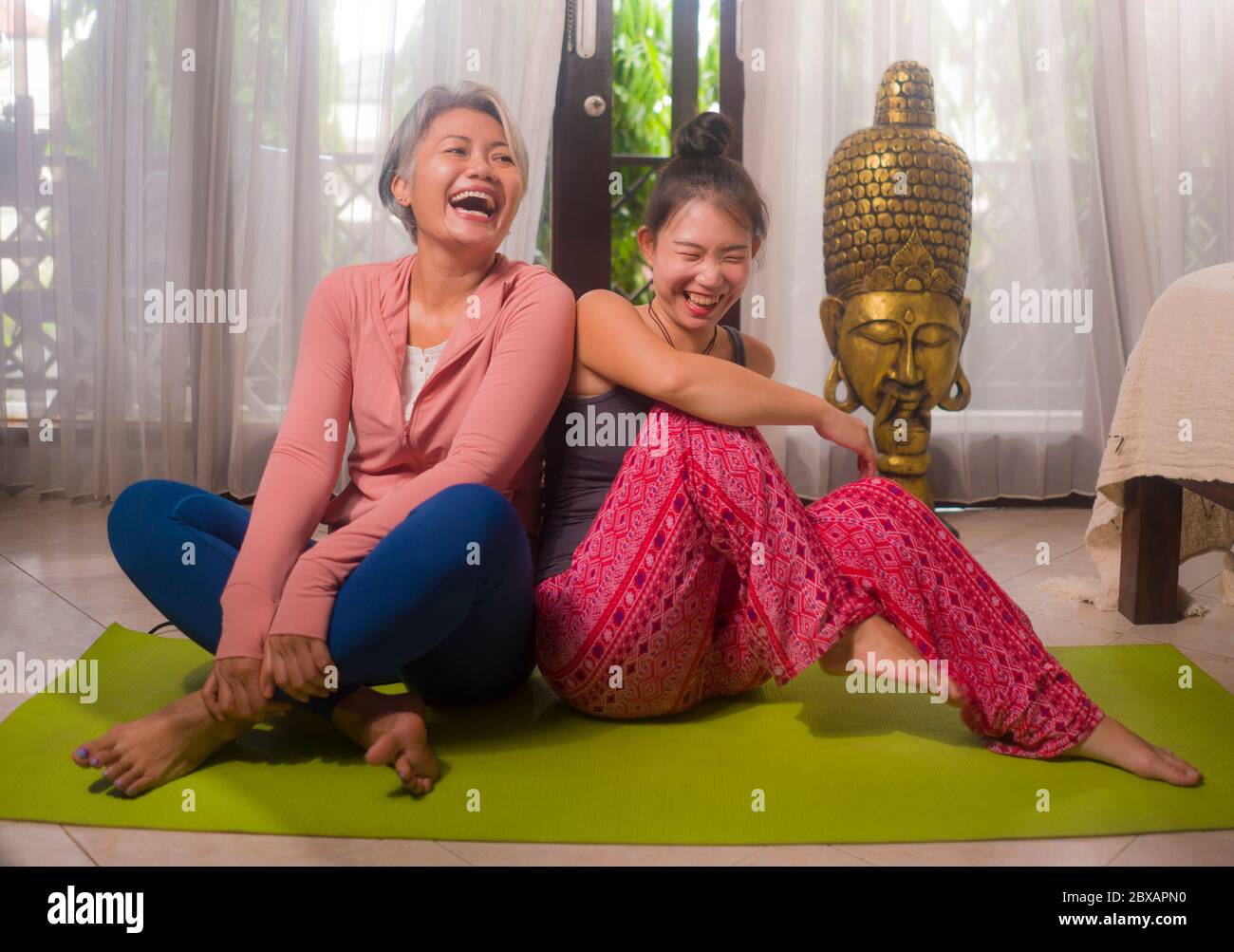 happy girlfriends enjoying yoga and fitness workout at home - two ...