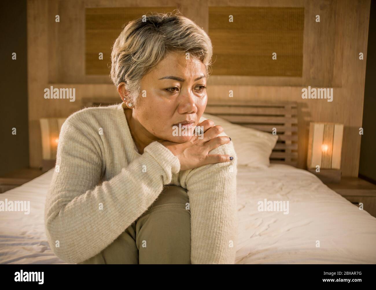 depressed and sad grey hair mature woman crying lonely sitting on bed ...
