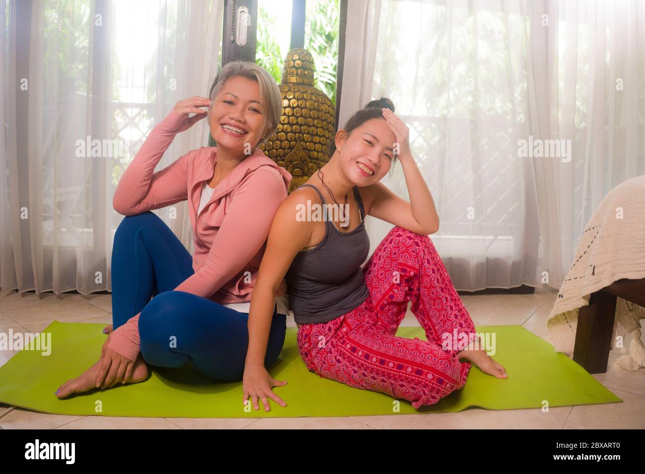 happy girlfriends enjoying yoga and fitness workout at home - two ...