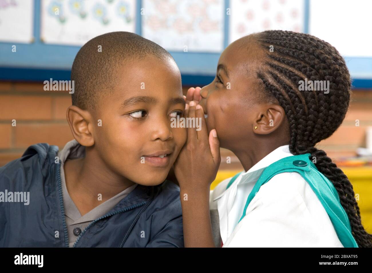 Girl whispering in boys' ear Stock Photo - Alamy
