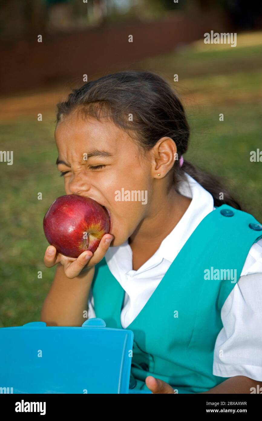 Schoolgirl biting into an apple Stock Photo - Alamy