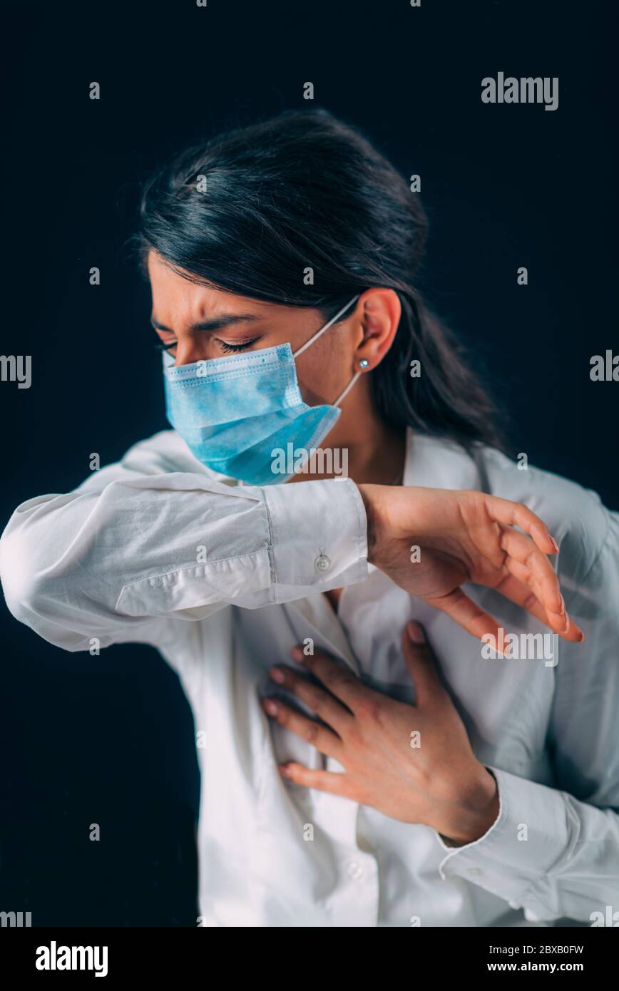 Coughing in elbow or sleeve Stock Photo - Alamy
