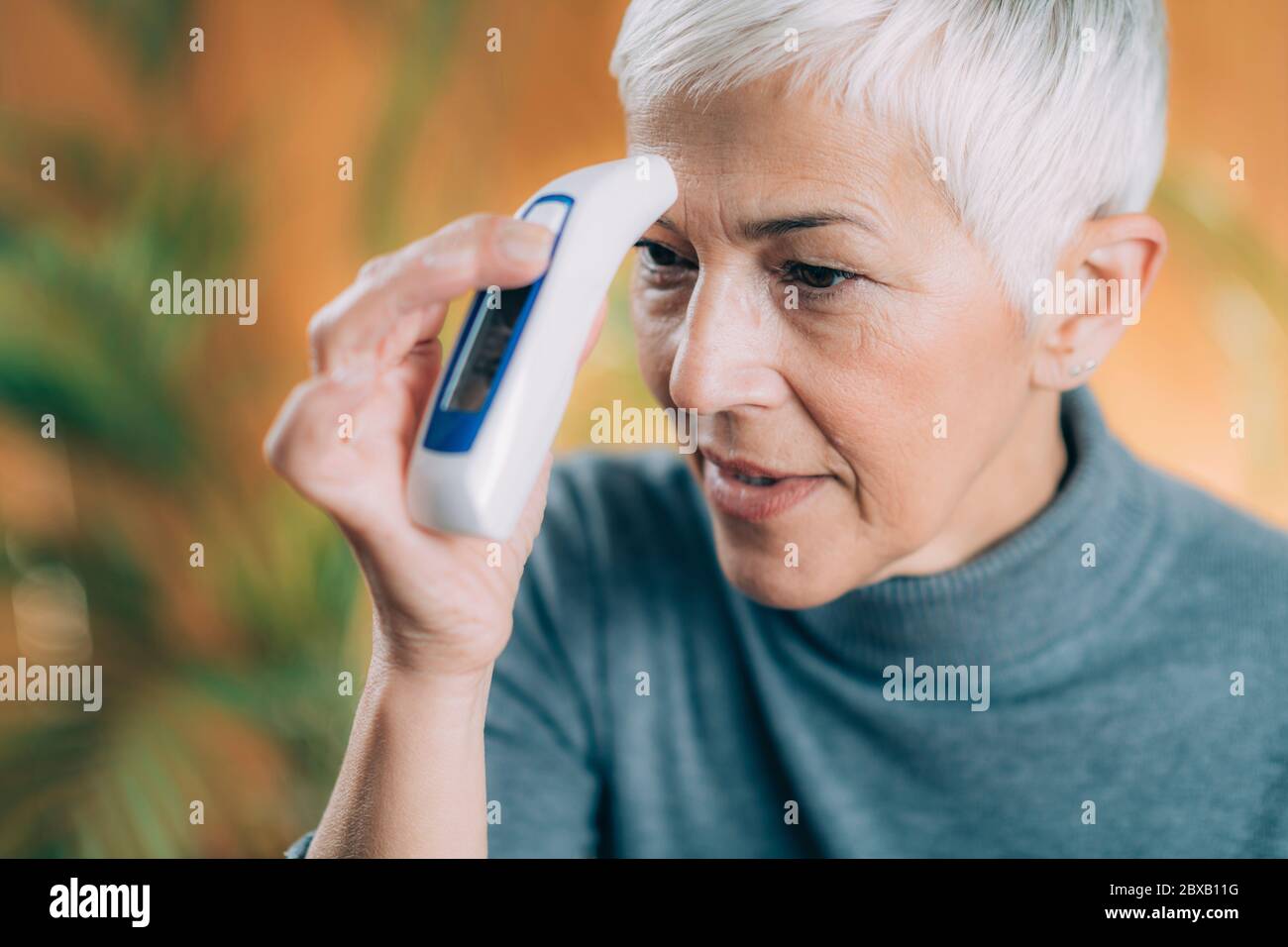 Measuring body temperature with contactless thermometer Stock Photo - Alamy