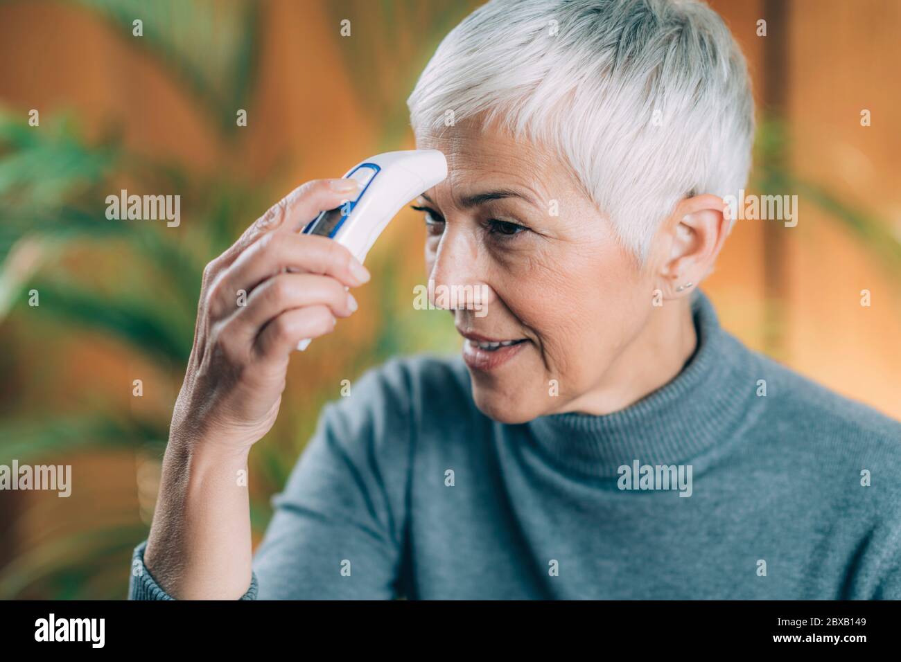 Measuring body temperature with contactless thermometer Stock Photo - Alamy