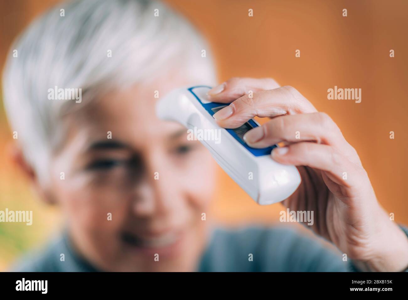 Measuring body temperature with non-contact thermometer Stock Photo - Alamy