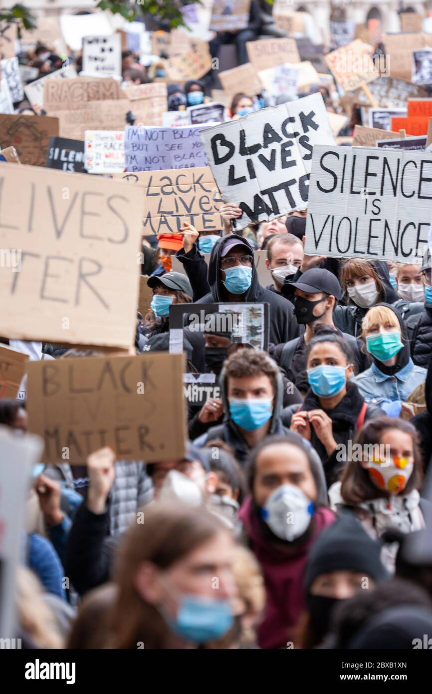 Crowds of people, wearing face masks and holding signs, at the Black ...