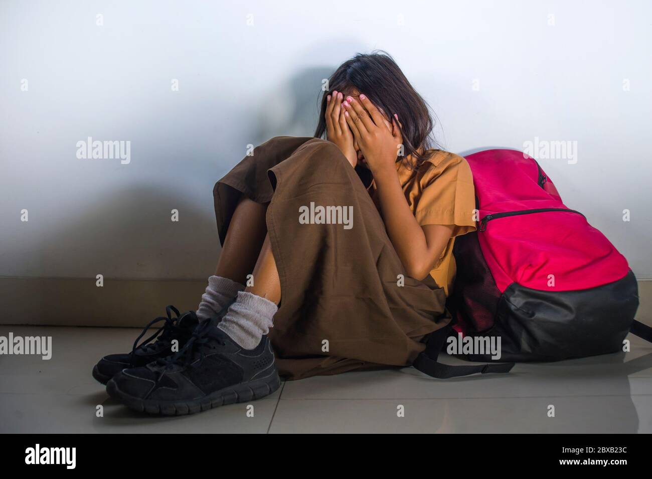 dramatic portrait of sad and depressed 8 or 9 years old child in school ...