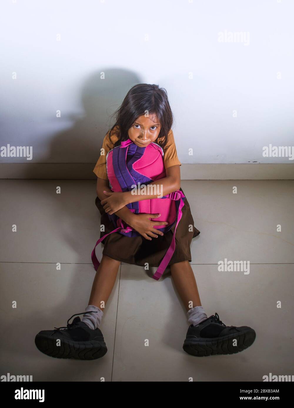 dramatic portrait of sad and depressed 8 or 9 years old child in school ...