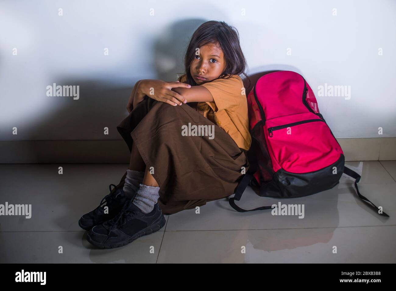 dramatic portrait of sad and depressed 8 or 9 years old child in school ...