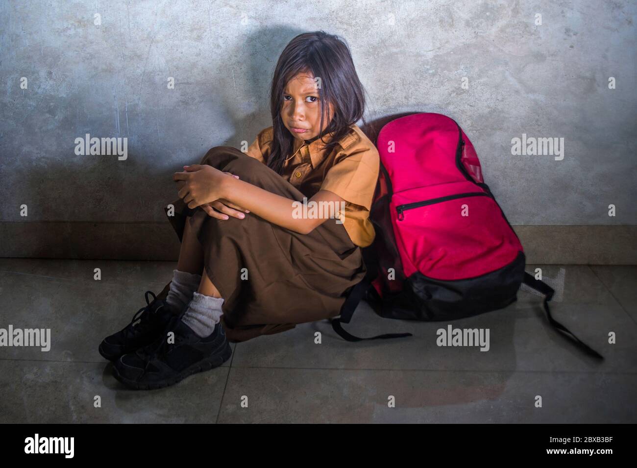 dramatic portrait of sad and depressed 8 or 9 years old child in school ...