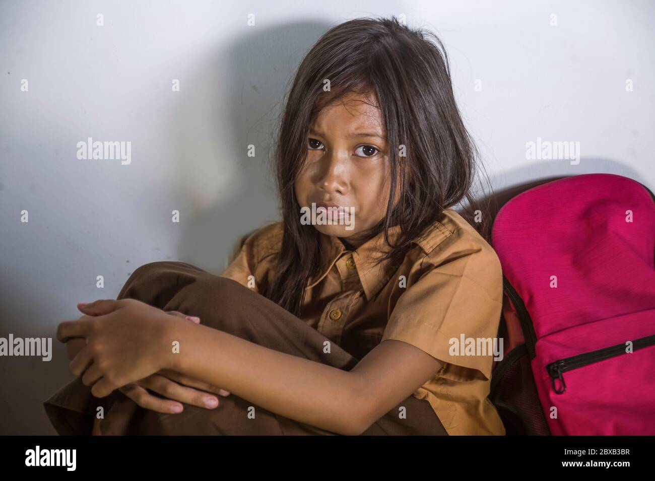 dramatic portrait of sad and depressed 8 or 9 years old child in school ...