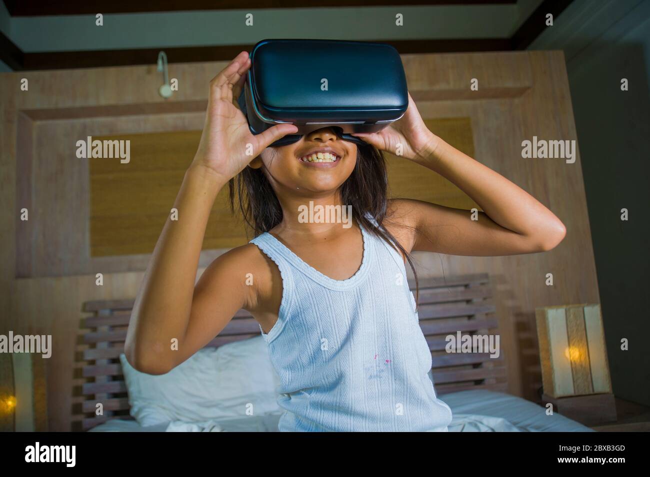 lifestyle portrait of young happy and excited female child wearing VR ...