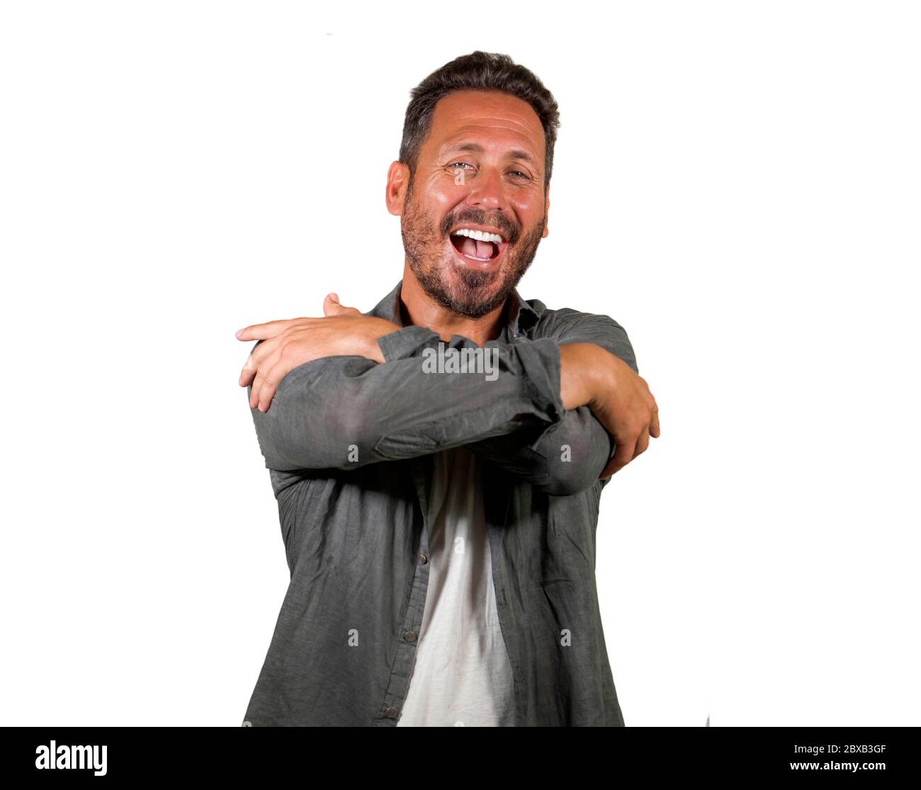 portrait of young happy and attractive man hugging himself smiling ...