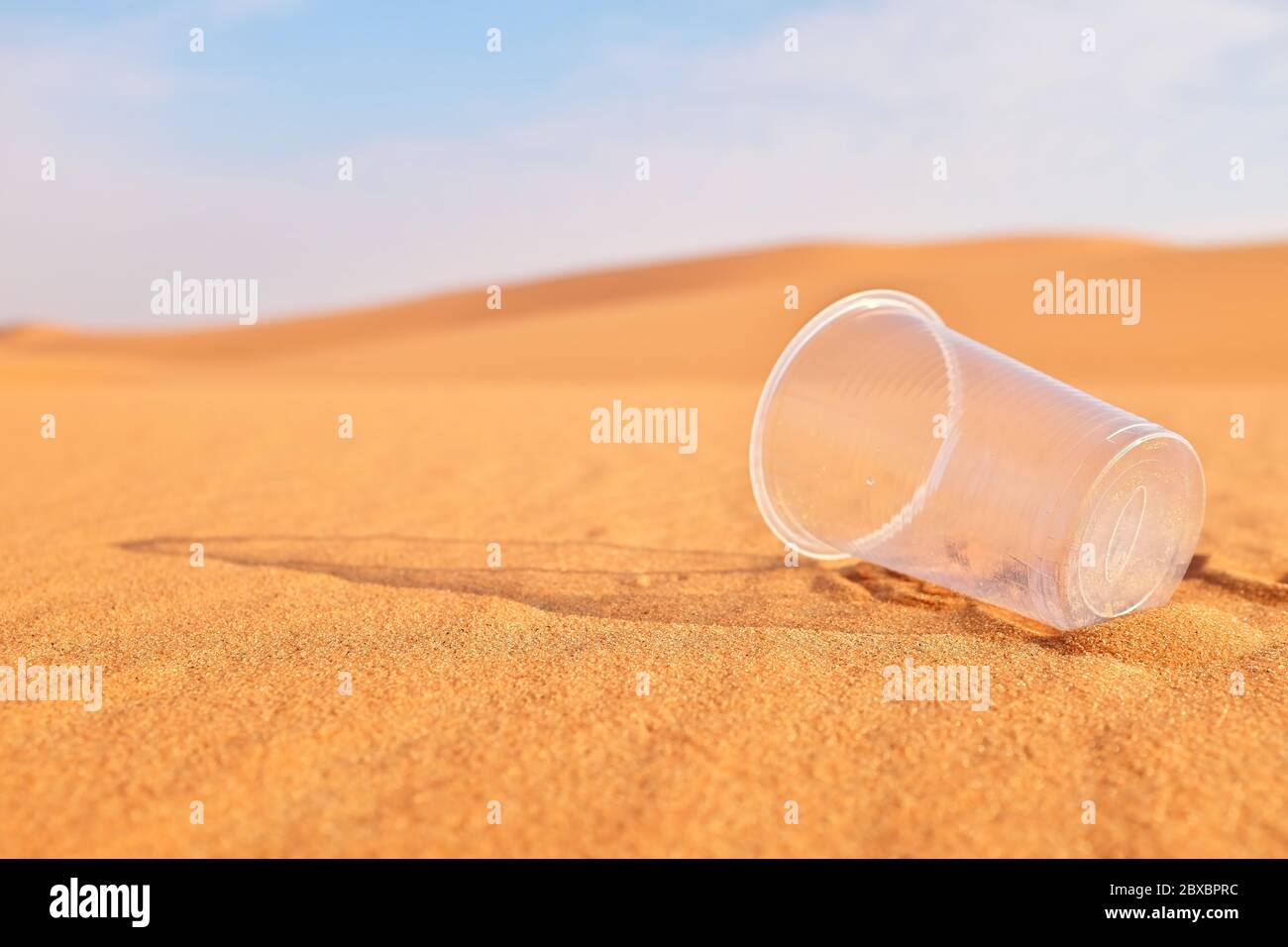 Empty glass of water in hot desert landscape. Water wastage ...