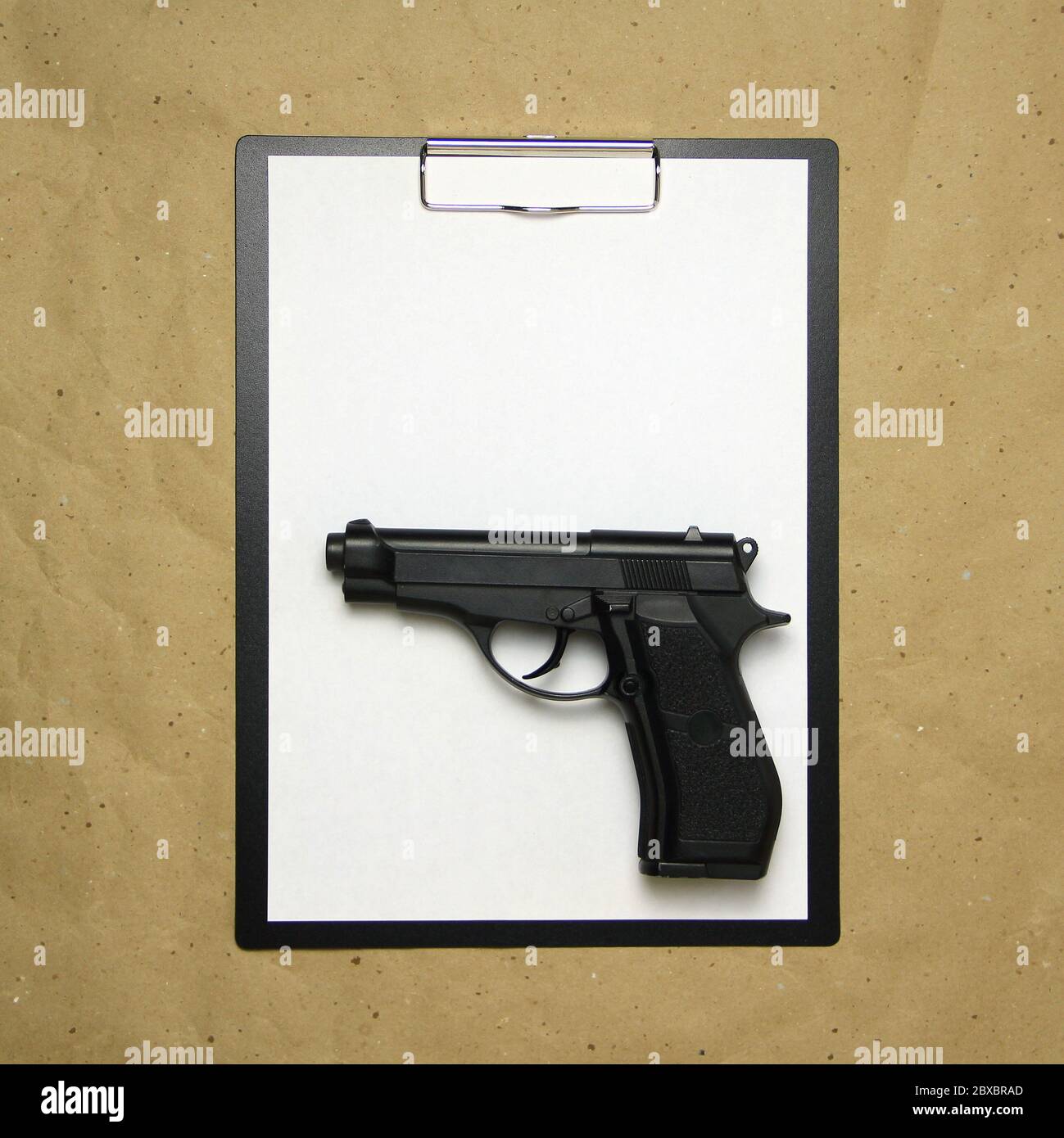 A tablet with a white sheet of A4 format with gun on a beige craft ...