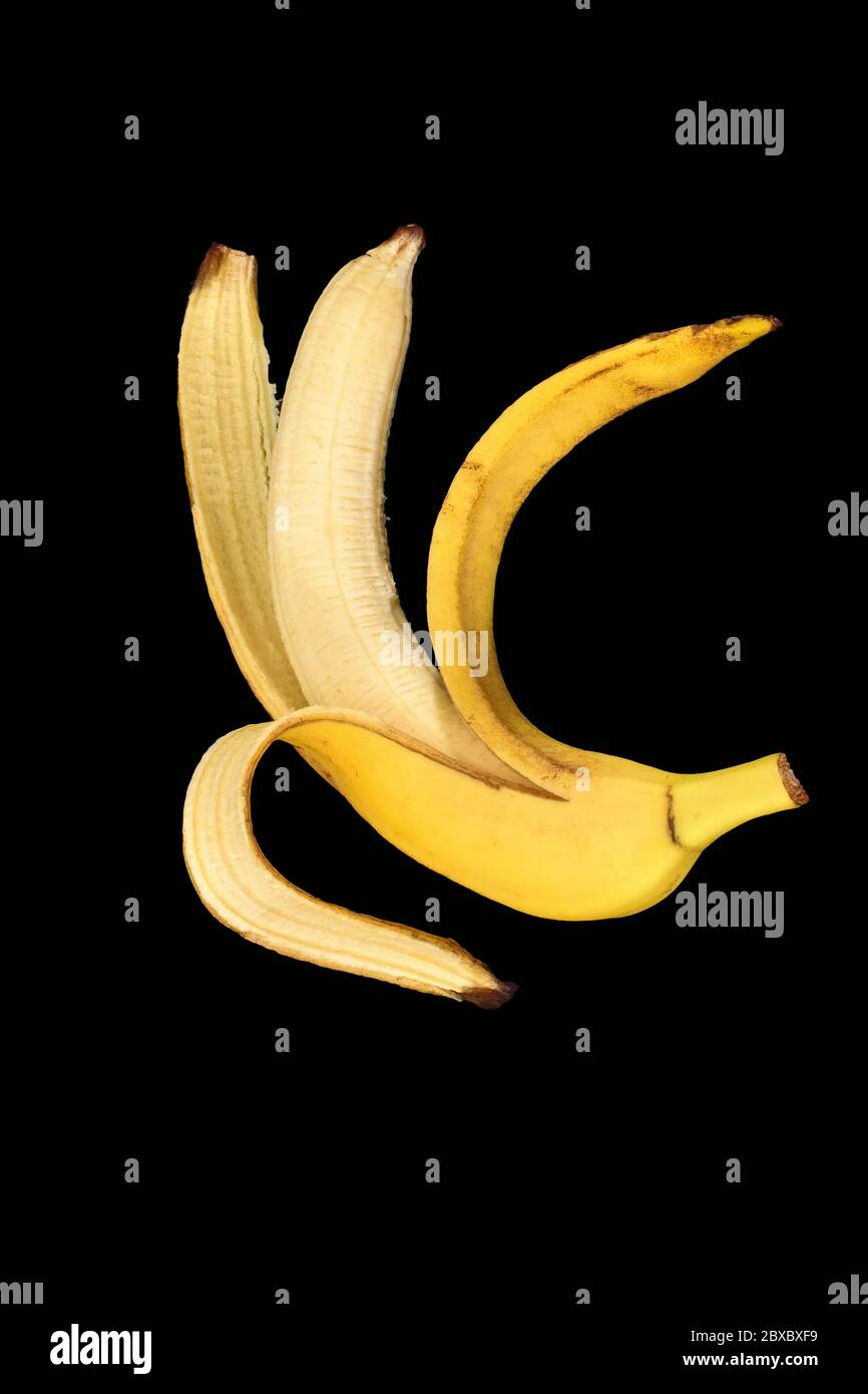 Peeled banana on a black background. Peel and inside of a ripe and ...