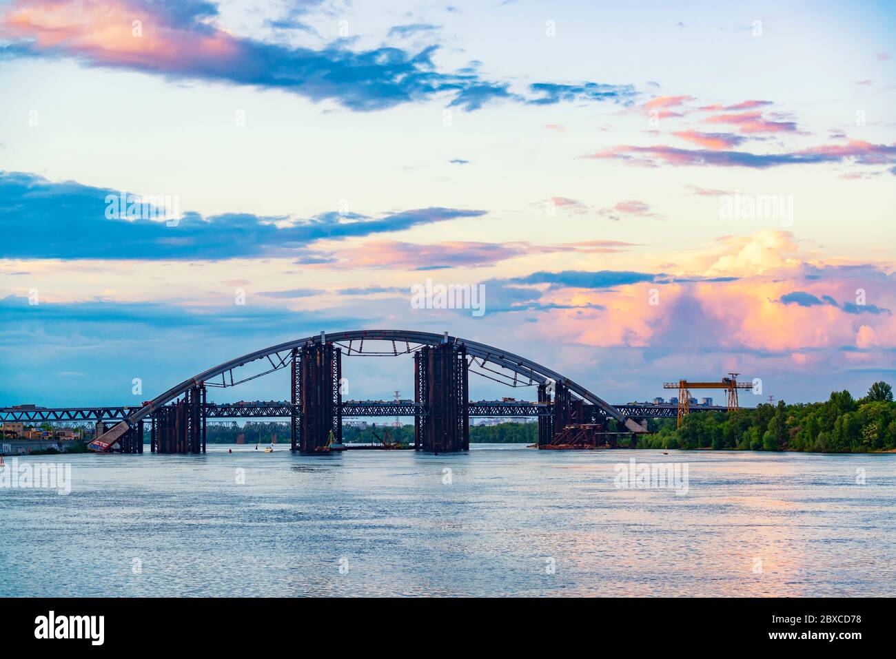 Modern arch bridge at the sunset. Construction of arch bridge in Kyiv ...