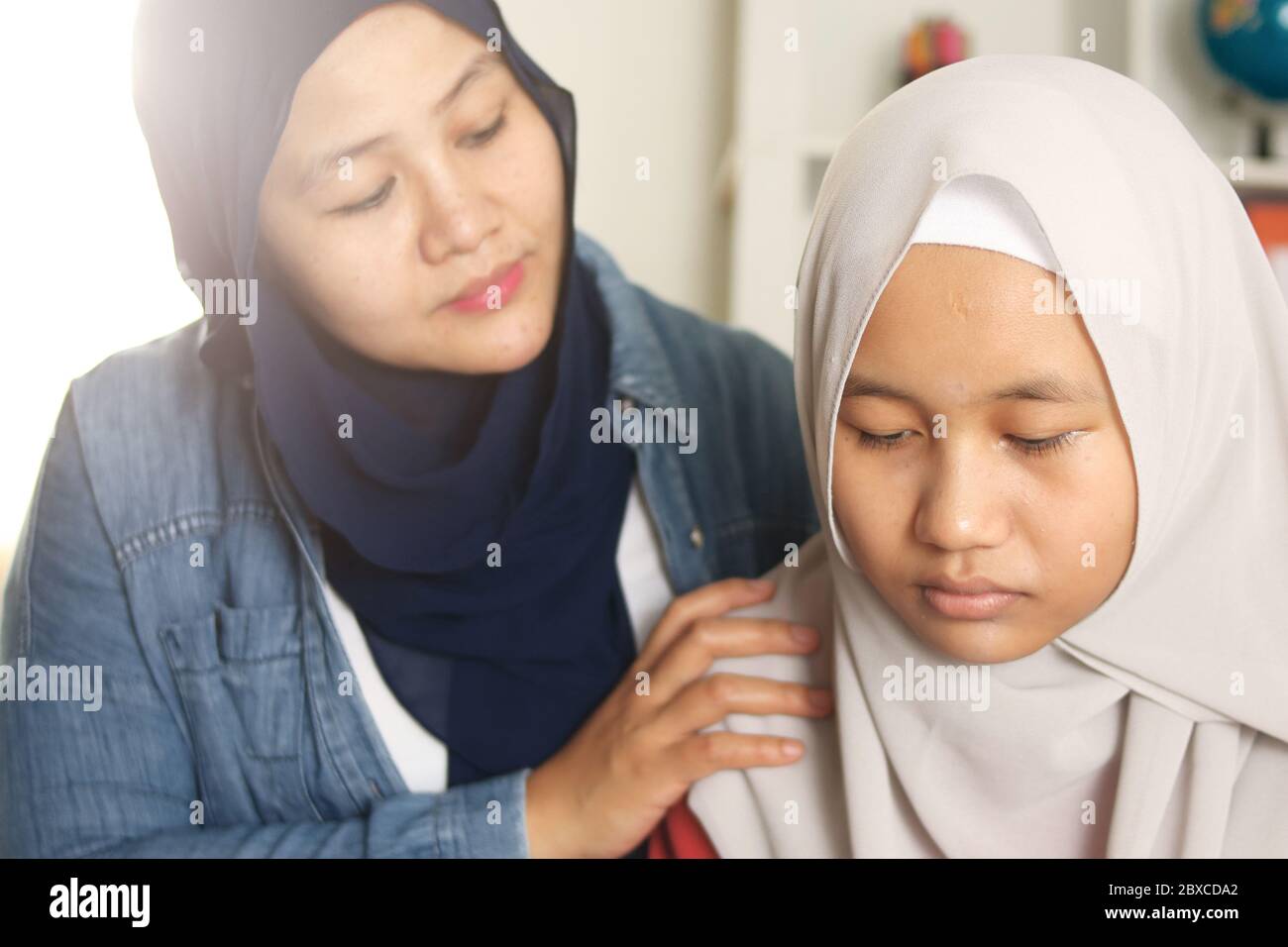 Muslim mother comforting her sad daughter, supportive mom help her ...