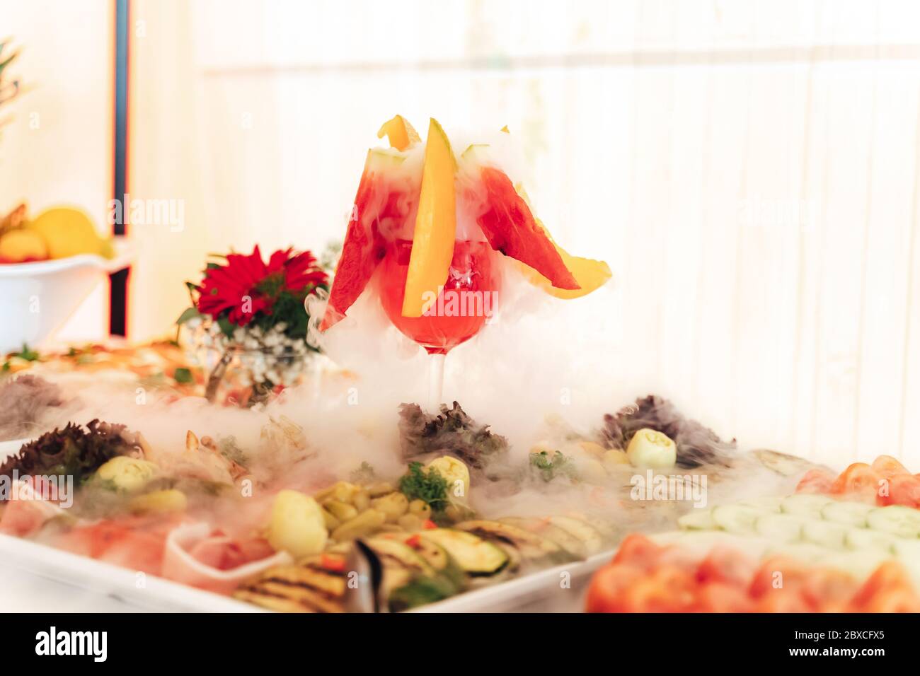 Smoking glass at fruit and vegetable buffet table. Closeup of glass of ...