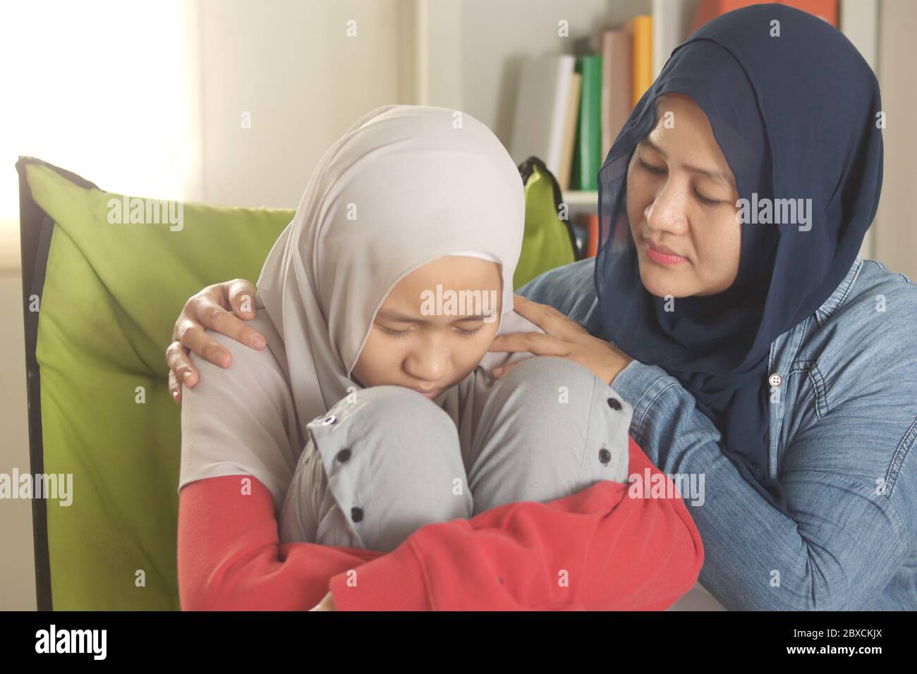 Muslim mother comforting her sad daughter, supportive mom help her ...