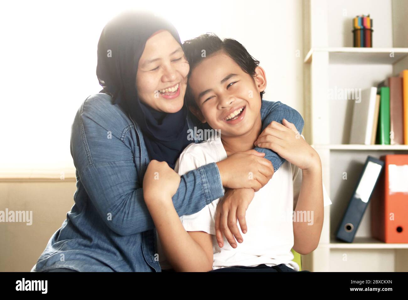 Happy Asian muslim mother wearing hijab hug her little boy, single mom ...