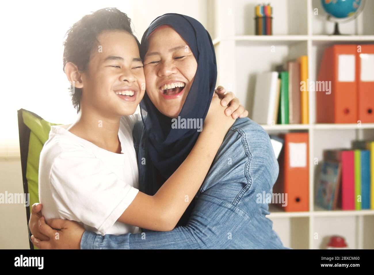 Happy Asian muslim mother wearing hijab hug her little boy, single mom ...